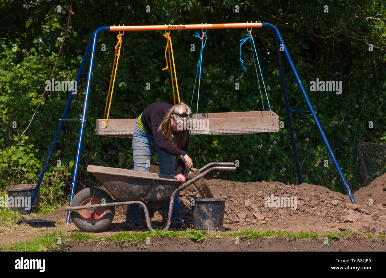 Archaeologist preparing to sieve earth at excavation of warehouse of ...