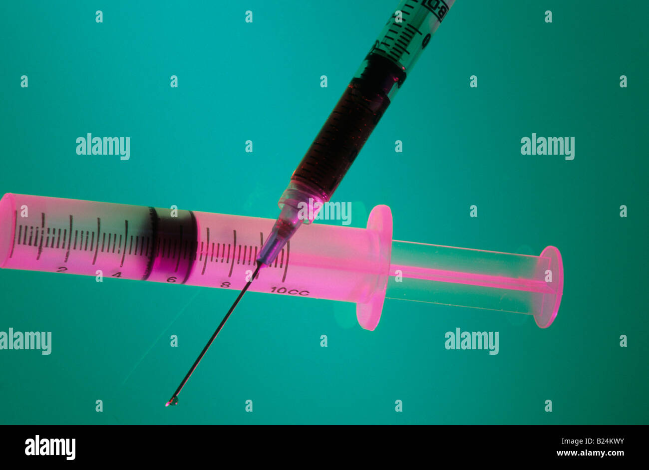 TWO SYRINGES WITH NEEDLES DRAMATIC LIGHTING Stock Photo - Alamy
