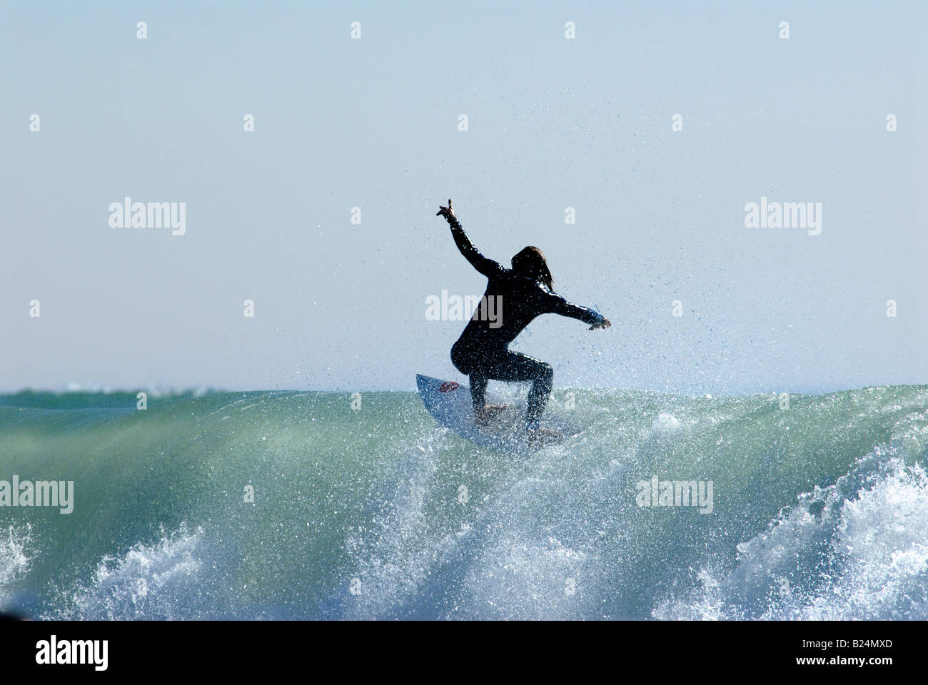 Surfer riding across top of breaking wave Stock Photo - Alamy