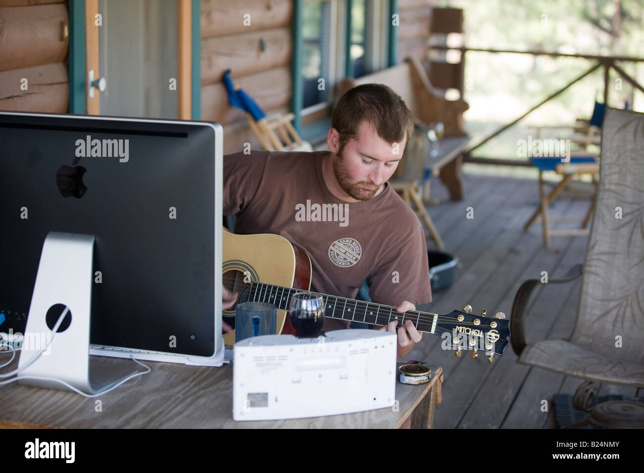 Young man with guitar writing a song on a computer Stock Photo - Alamy