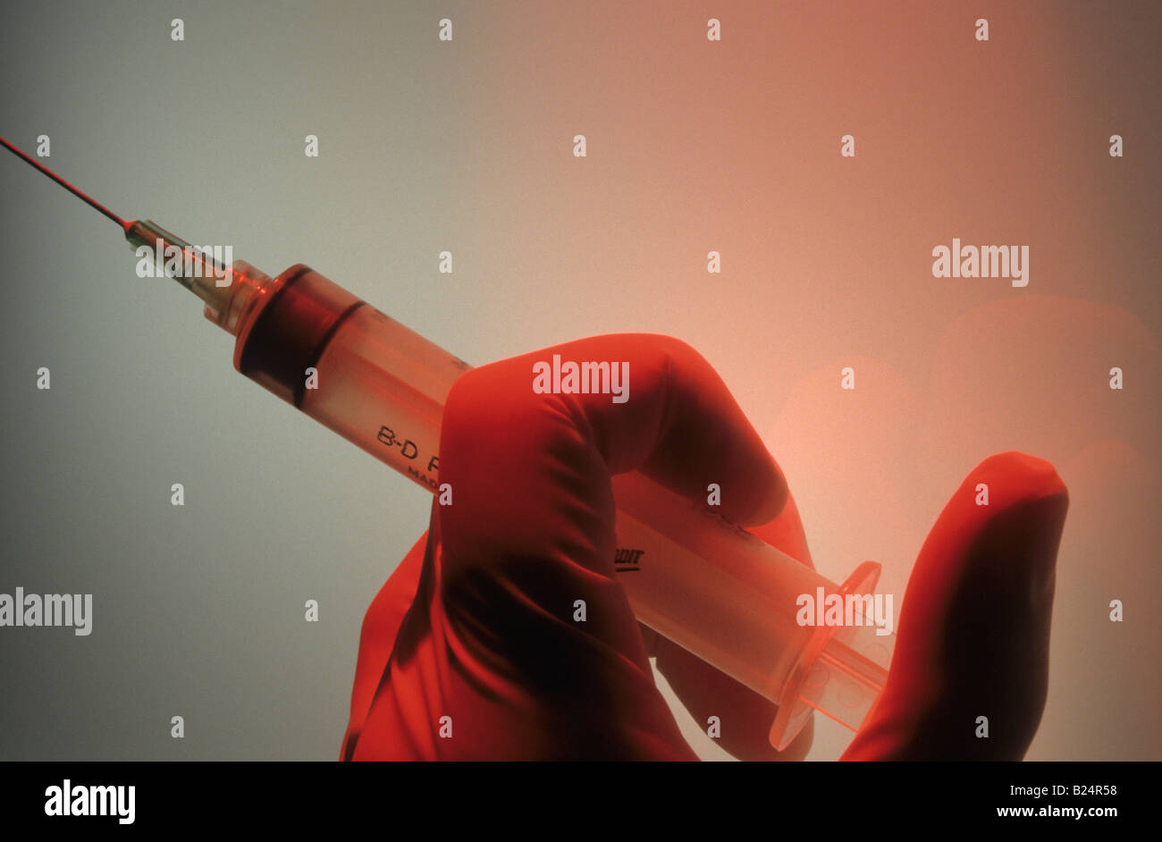 GLOVED HAND HOLDING SYRINGE DRAMATIC LIGHTING Stock Photo - Alamy