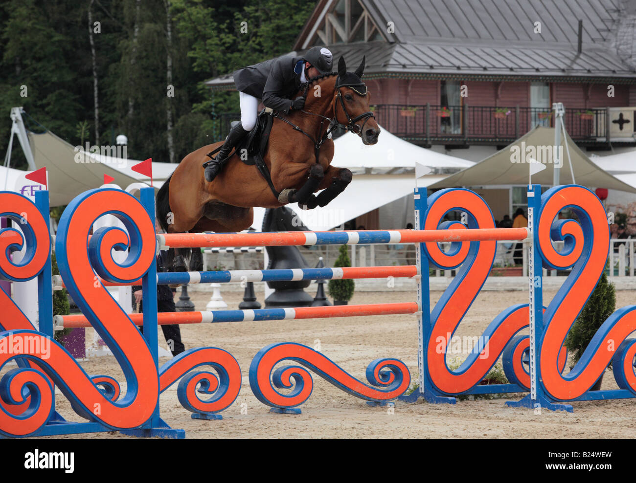 Horseman jumping obstacle in showjumping competition Stock Photo - Alamy