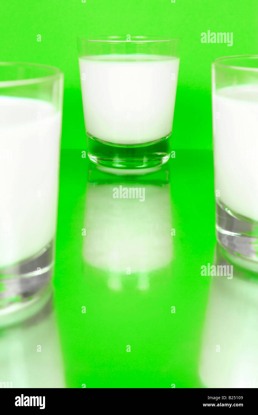 Glasses of full cream milk isolated against a green background Stock ...