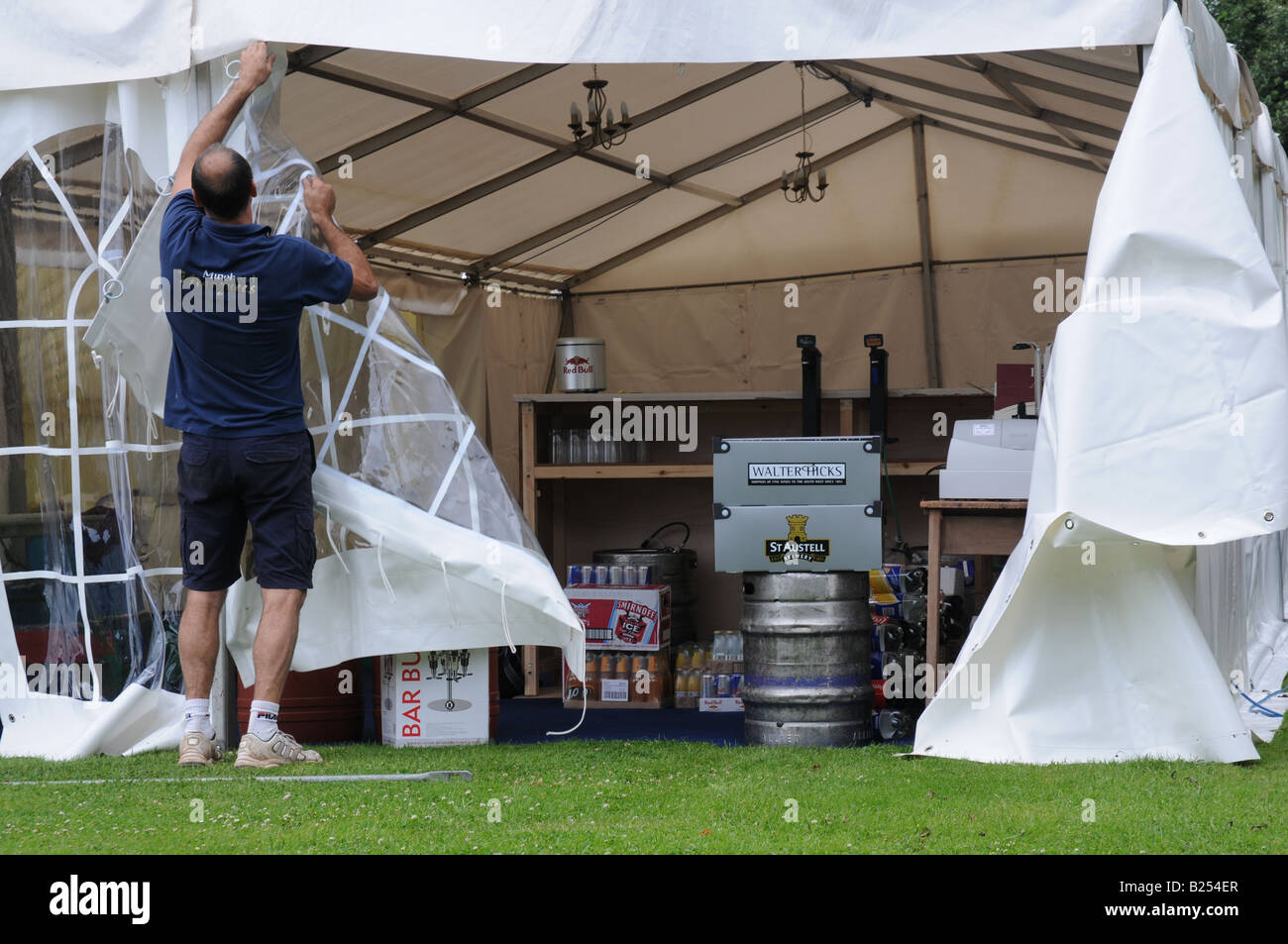 A man putting up a wedding marquee Stock Photo - Alamy