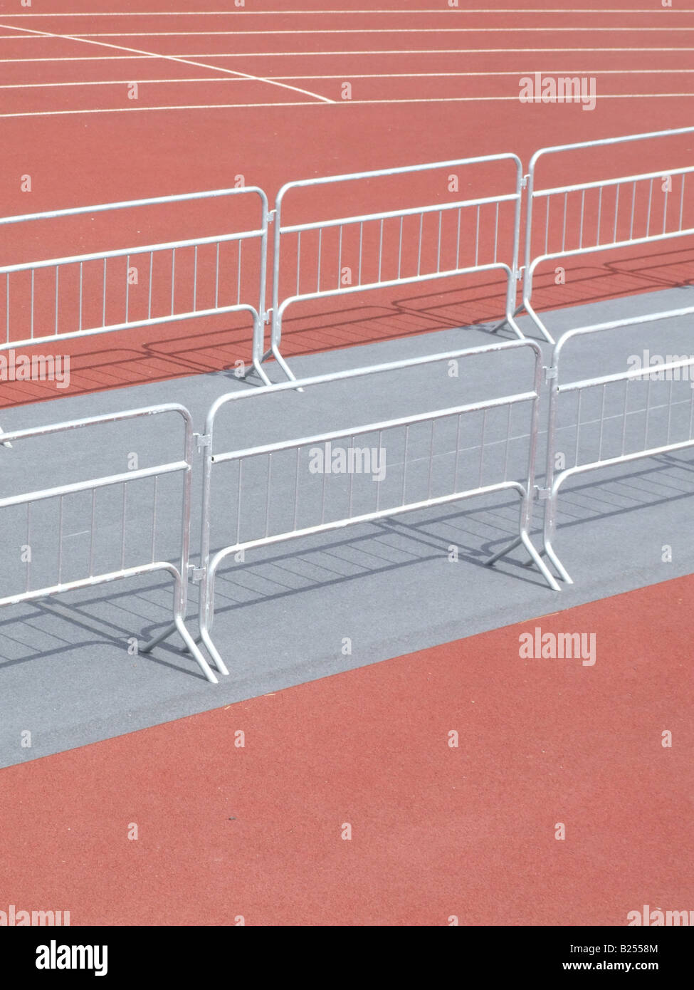 rows of many metal crowd control barriers gates on athletics track ...