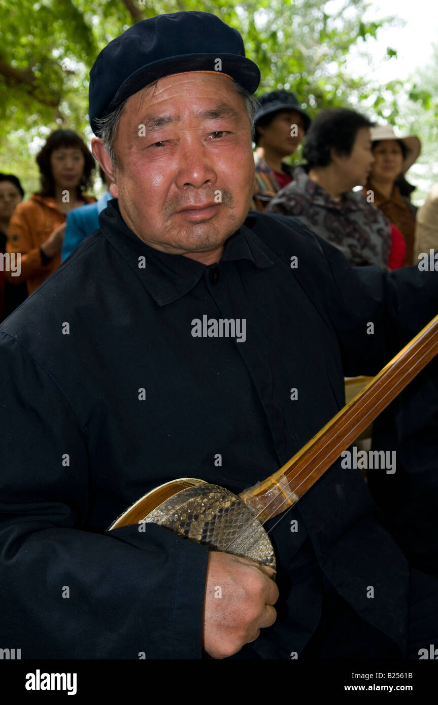 Portrait of a Chinese man playing a traditional musical instrument ...
