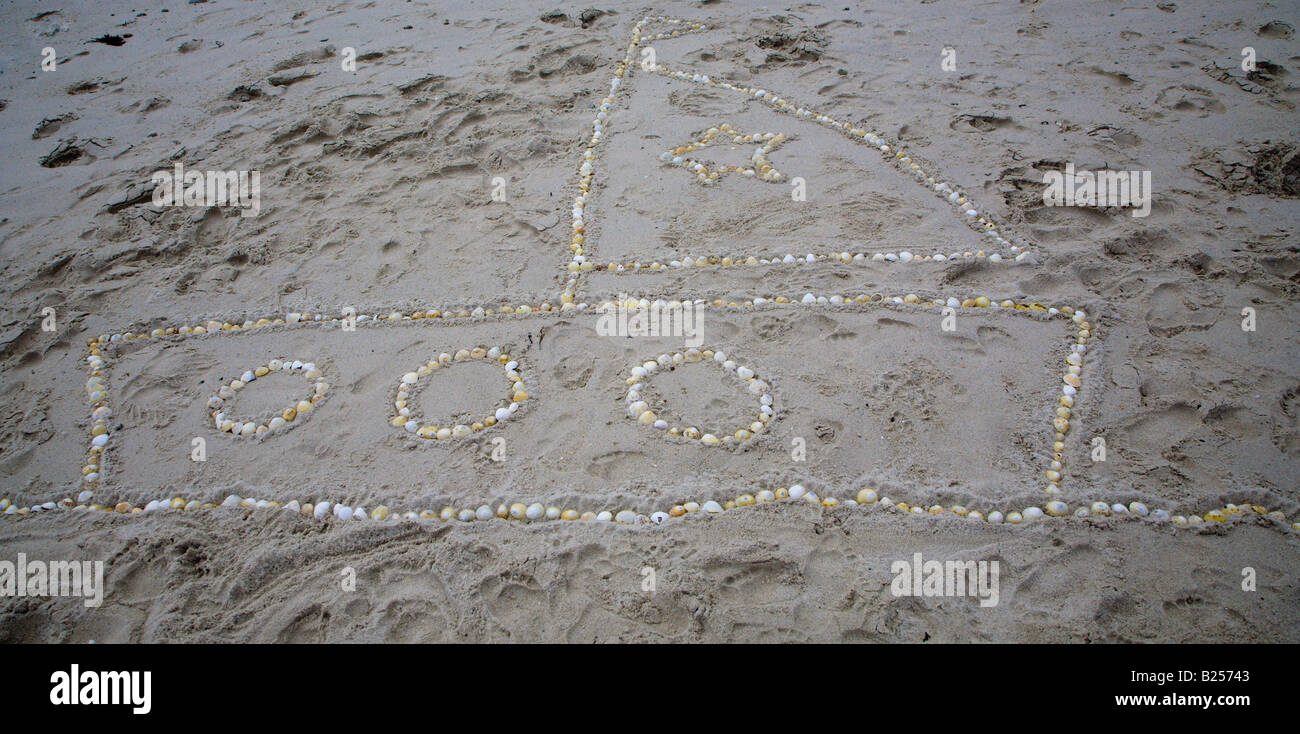 Seashell design of sailing boat on beach Stock Photo - Alamy