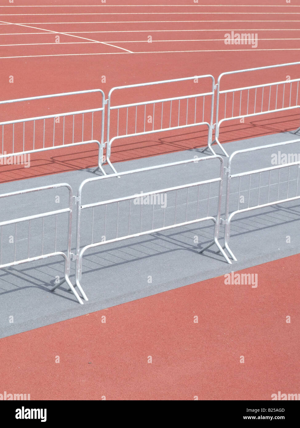 rows of many metal crowd control barriers gates on athletics track ...