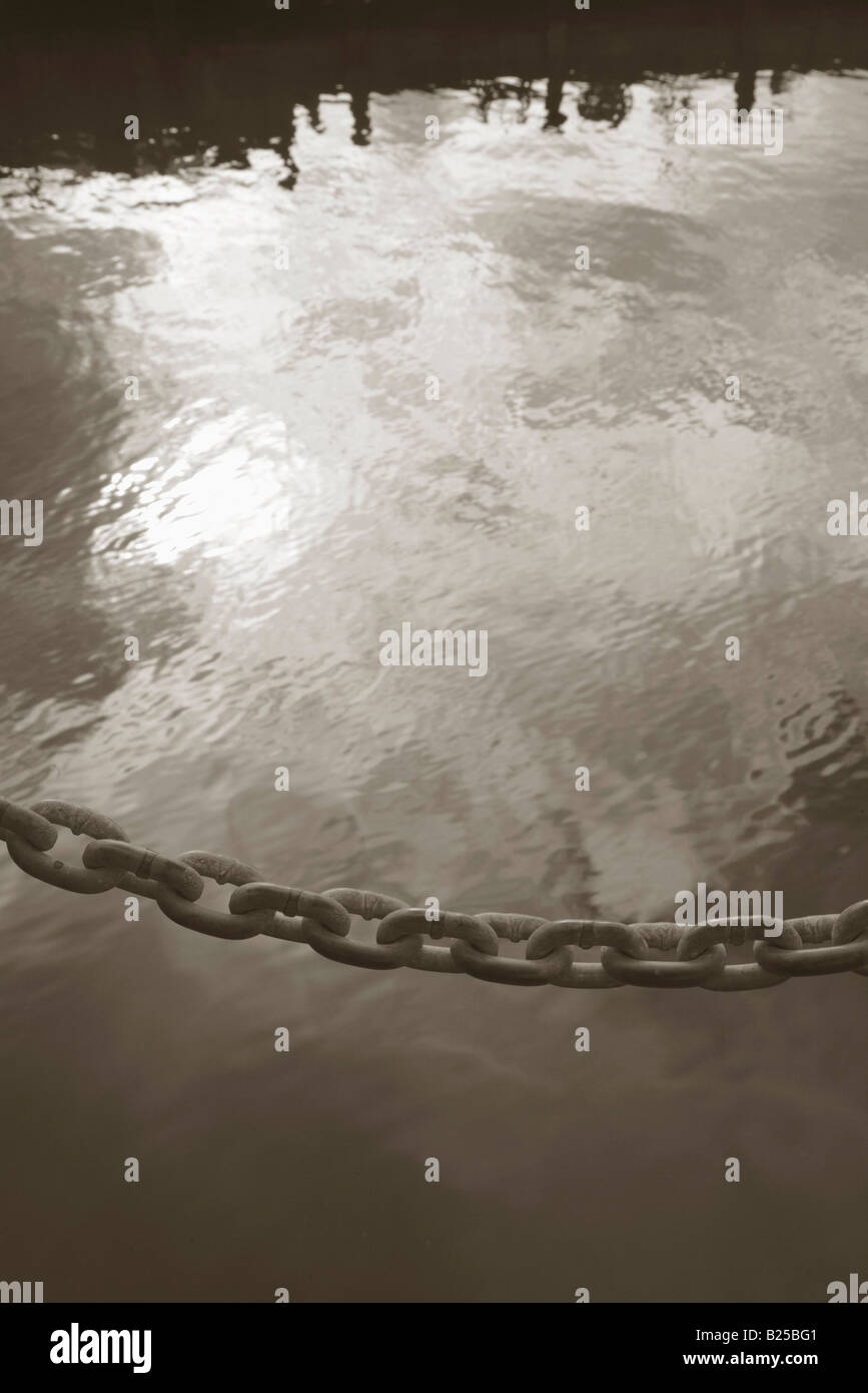 Big grey chain links with a reflective water background Stock Photo - Alamy