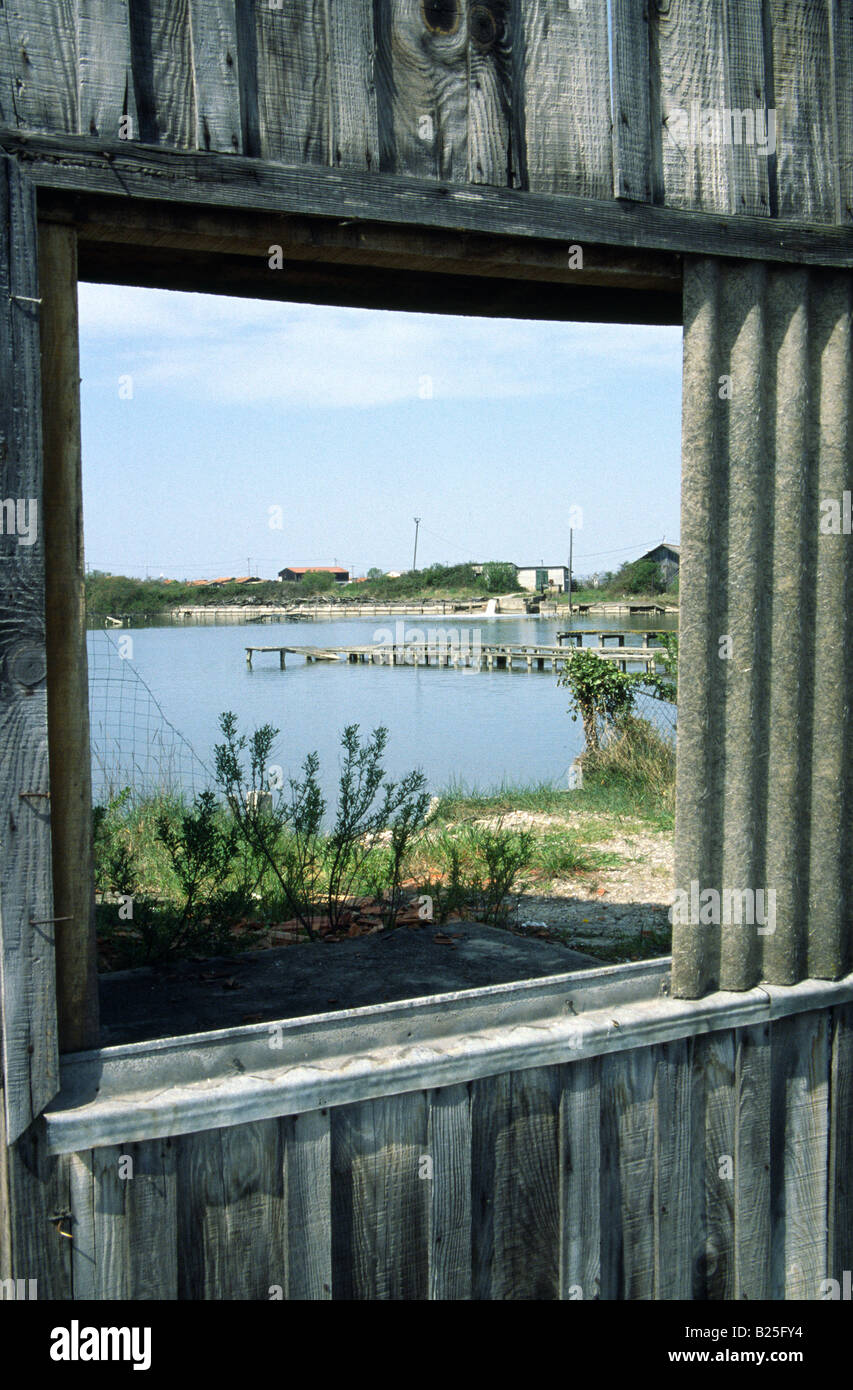 Wooden pier in Gujan Mestras seen through a wooden window in a wall ...