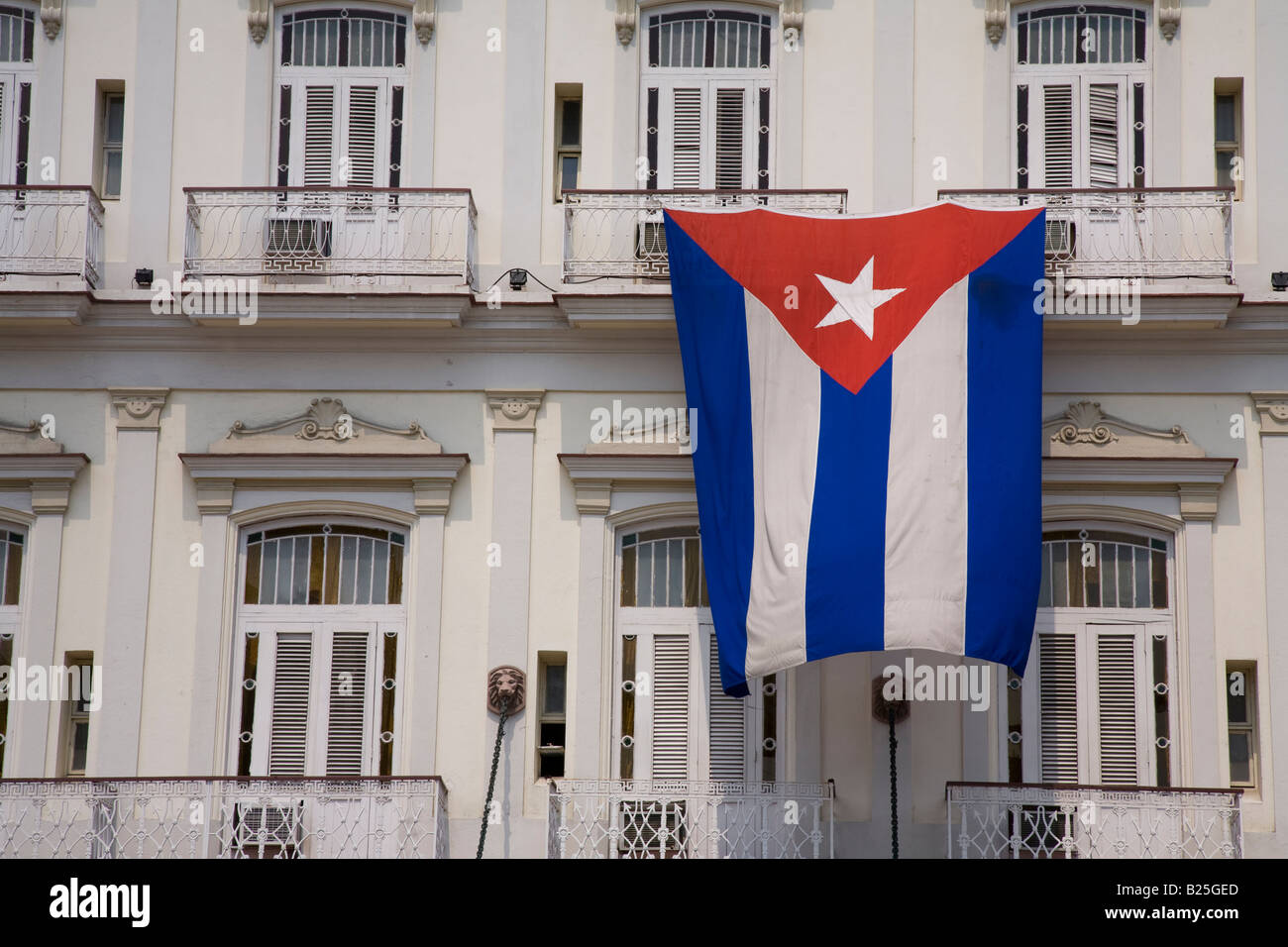 Cuban flag hanging outside a white balconied building in Havana Stock ...