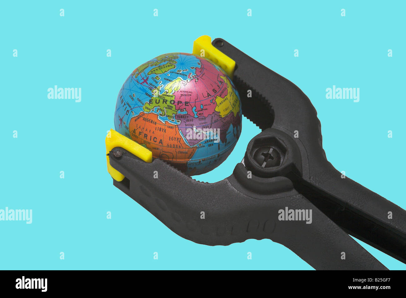 Globe trapped in a vice, isolated against a blue background Stock Photo ...