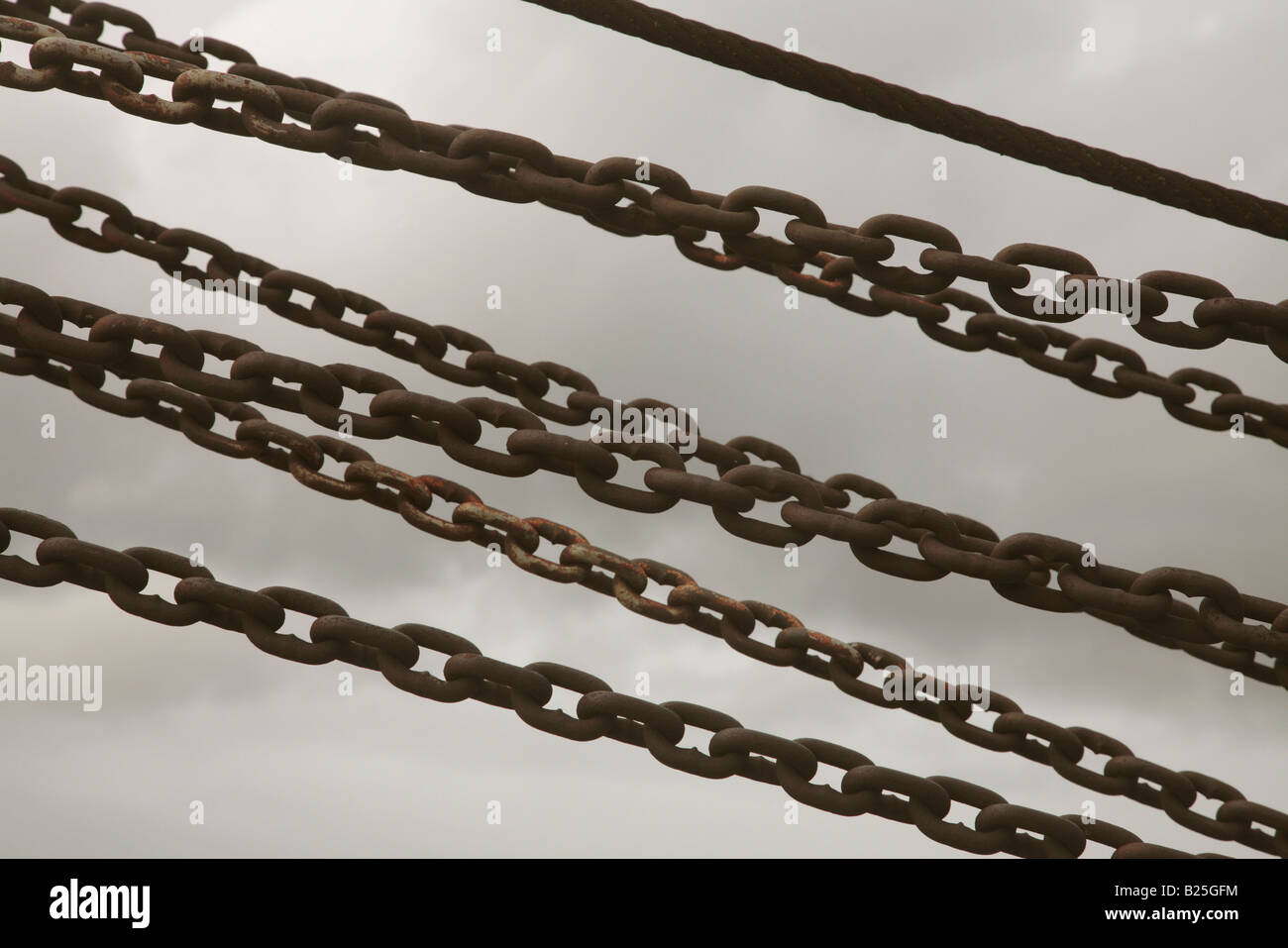 Rusting taught chain links with stormy sky background Stock Photo - Alamy