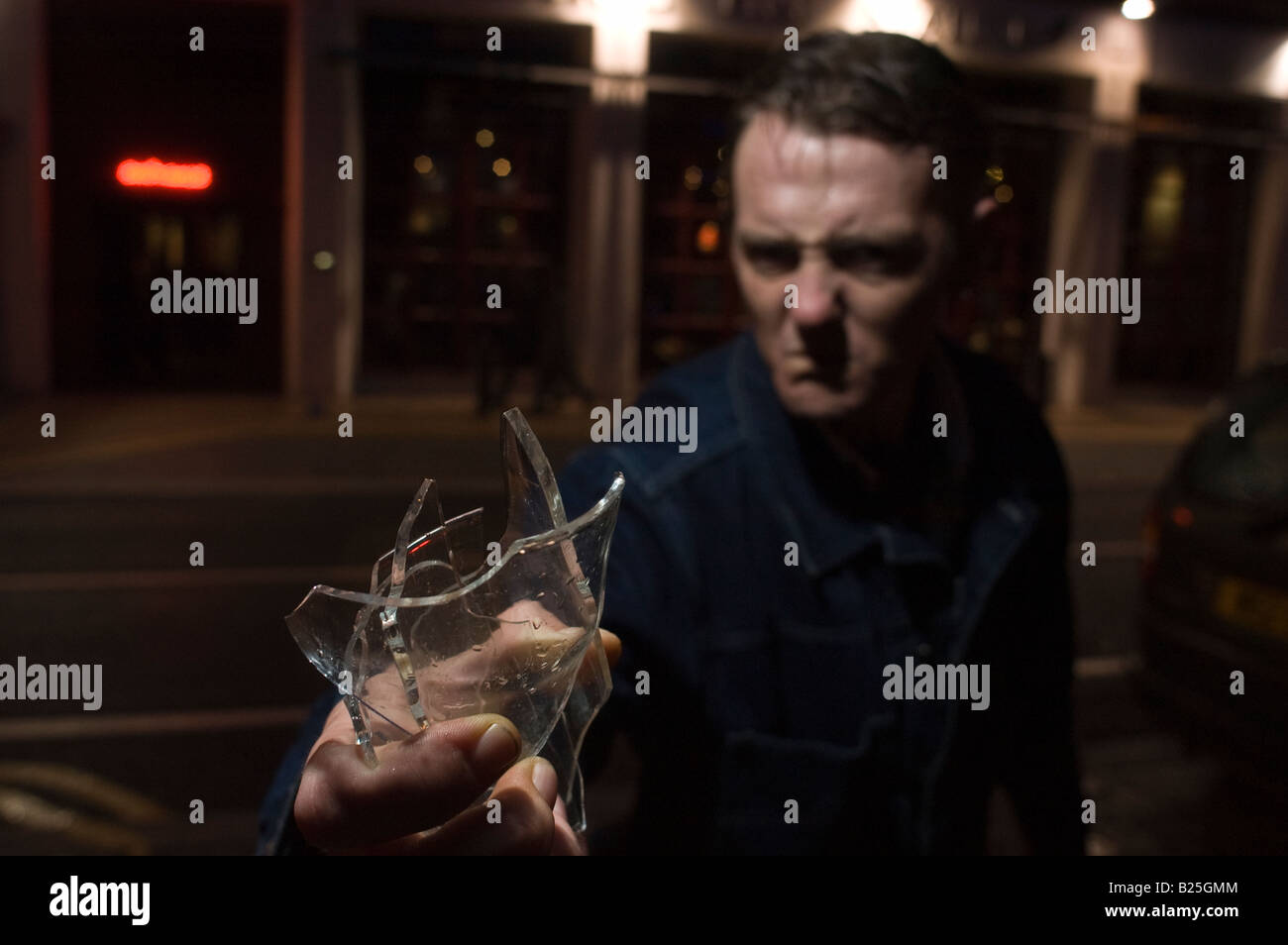 Threating man with a broken glass bottle Stock Photo - Alamy