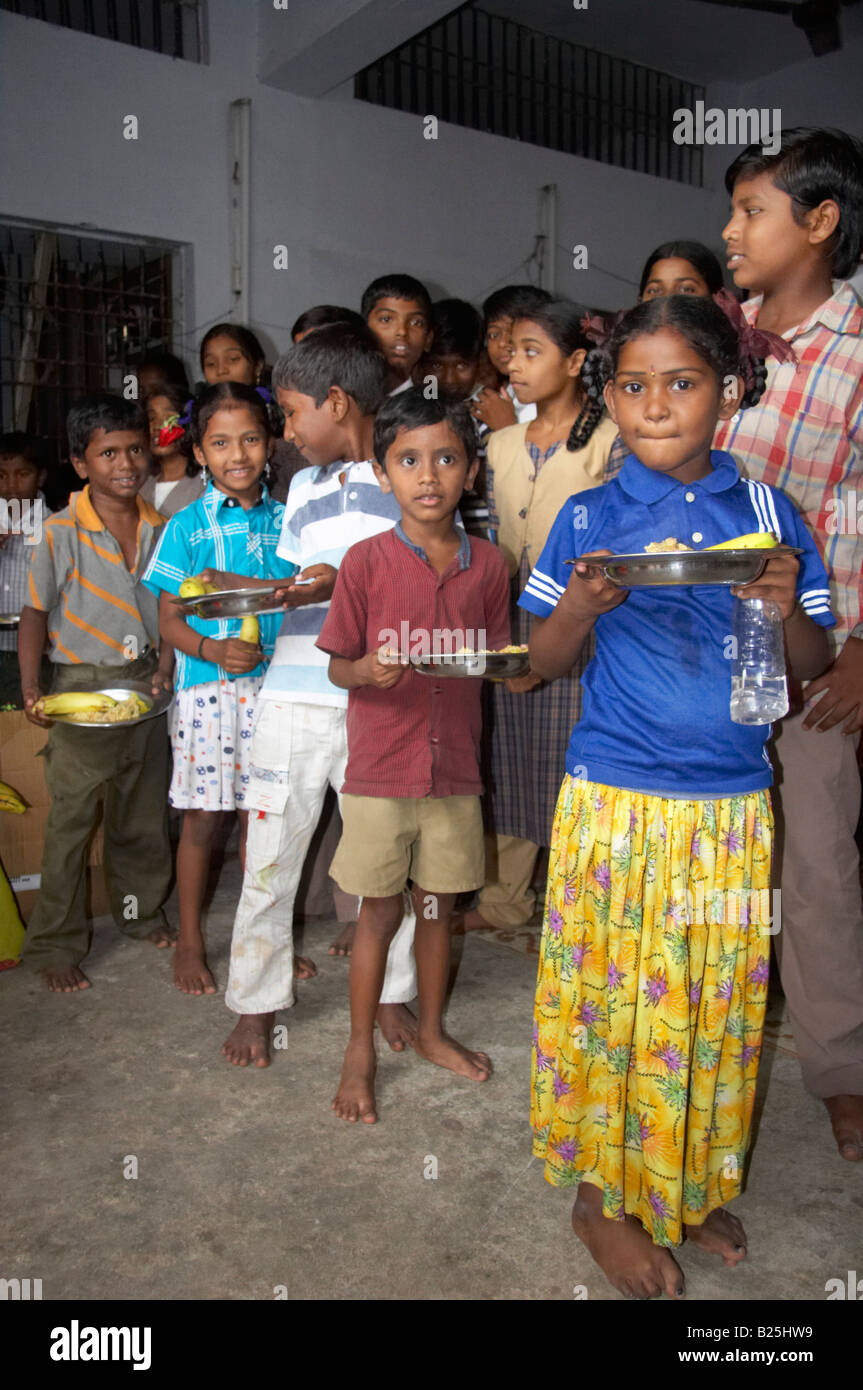 Indian children receive plates of food at the Compassion Ayanavaram ...