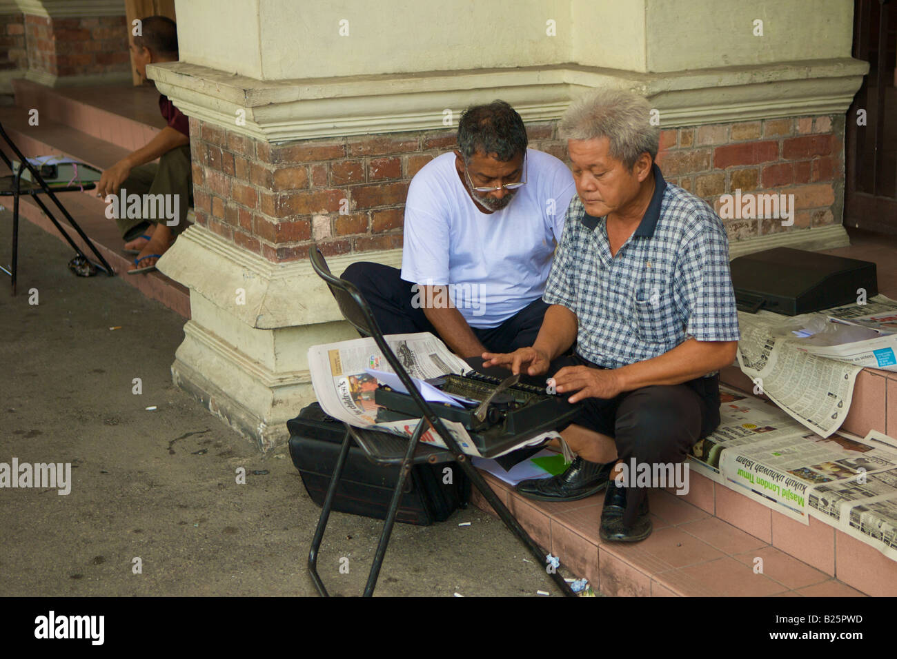 Malaysian street typist typing out forms outside the Kuala Lumpur Court ...