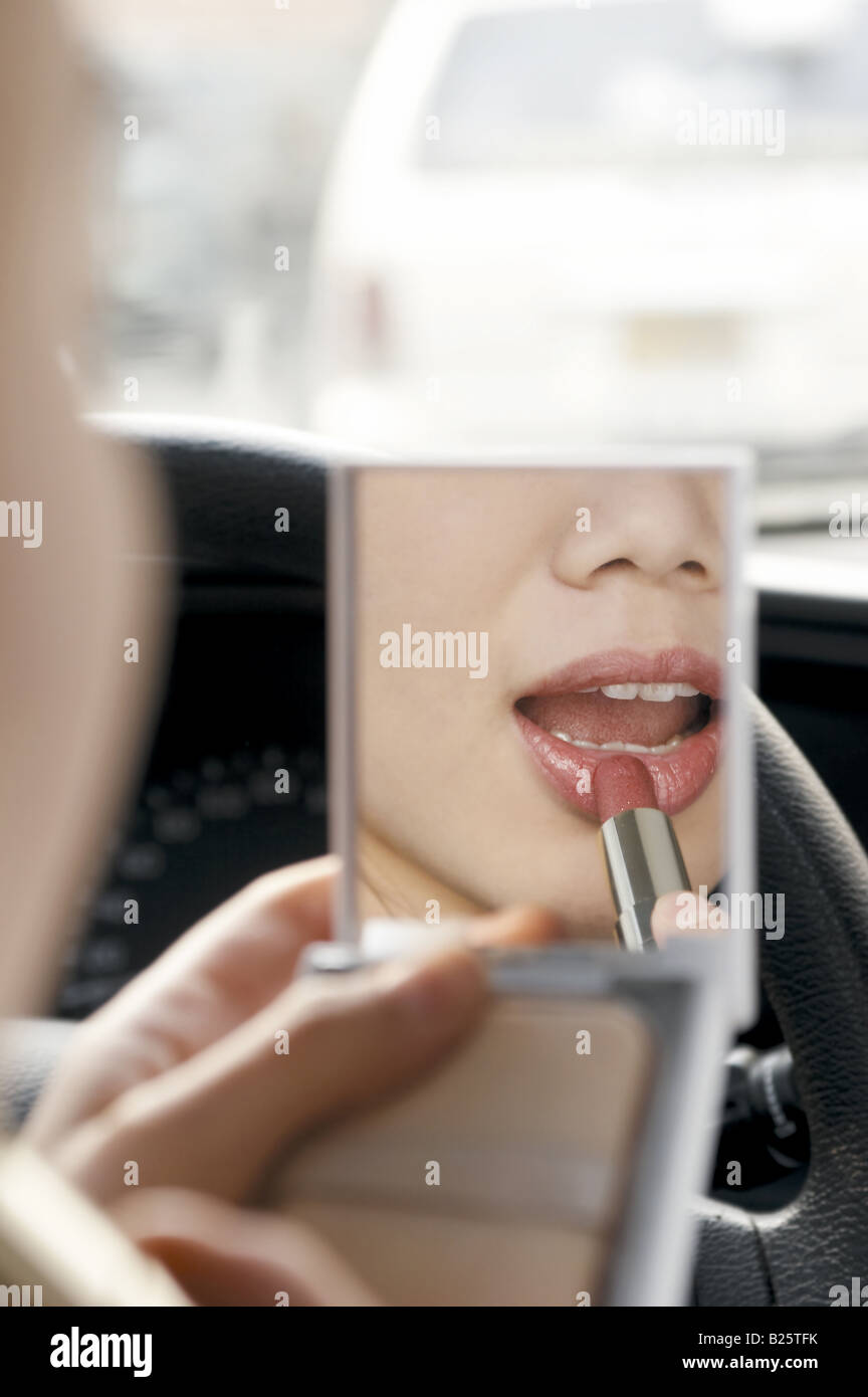 Woman applying lipstick Stock Photo - Alamy