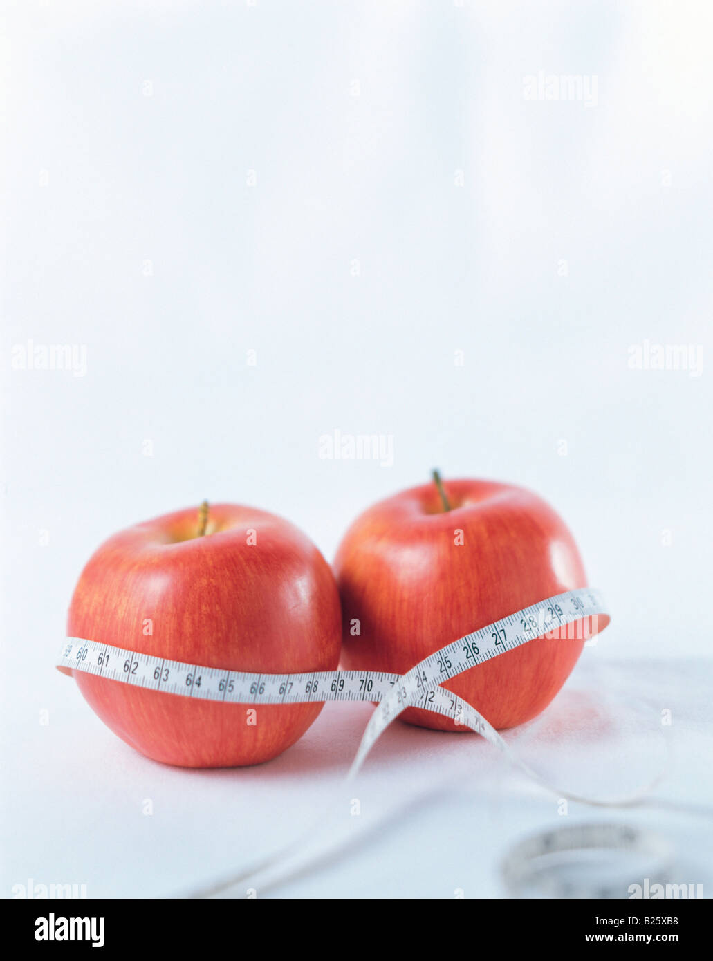 Two apples with measuring tape Stock Photo - Alamy