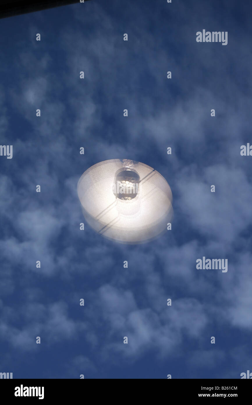 one light bulb reflection on glass window with white clouds and blue ...