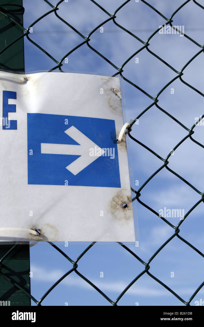 blue direction arrow sign on fence outdoors Stock Photo - Alamy