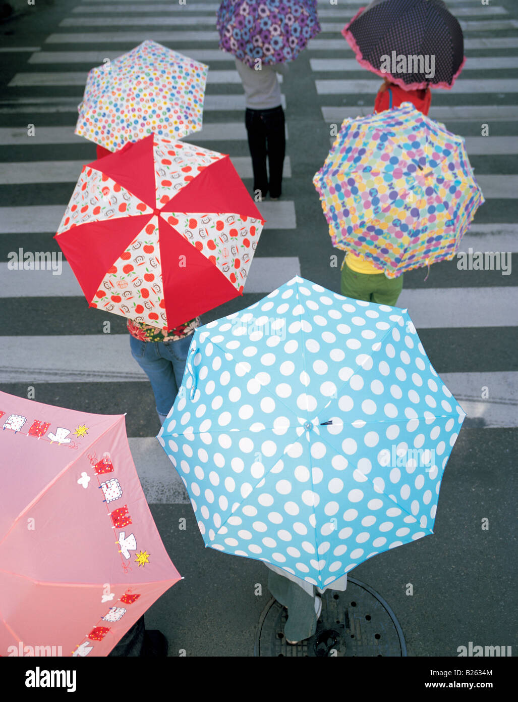 People holding umbrellas on a crossing Stock Photo - Alamy