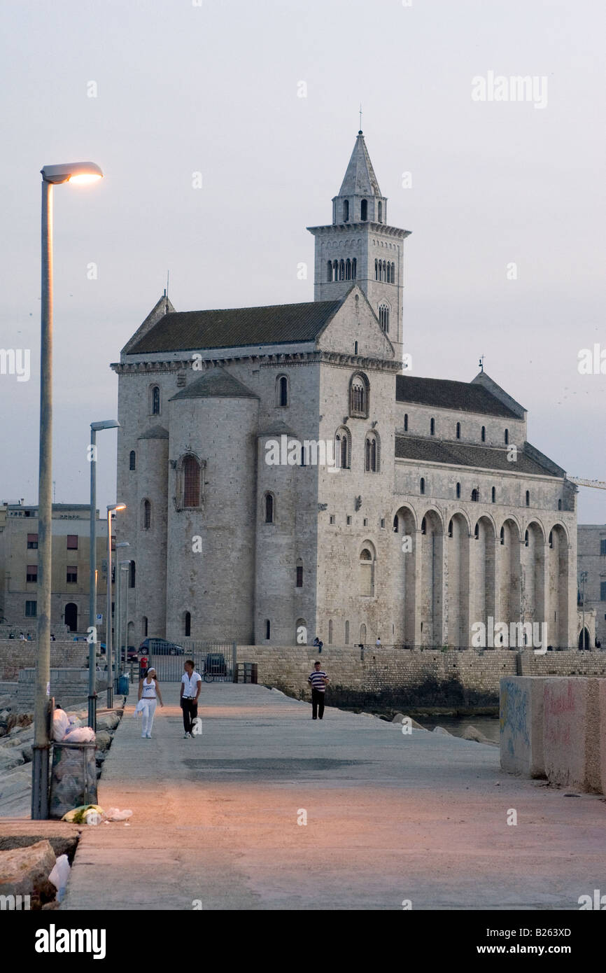 The cathedral in Trani, Italy. People walk on the promenade in front of ...