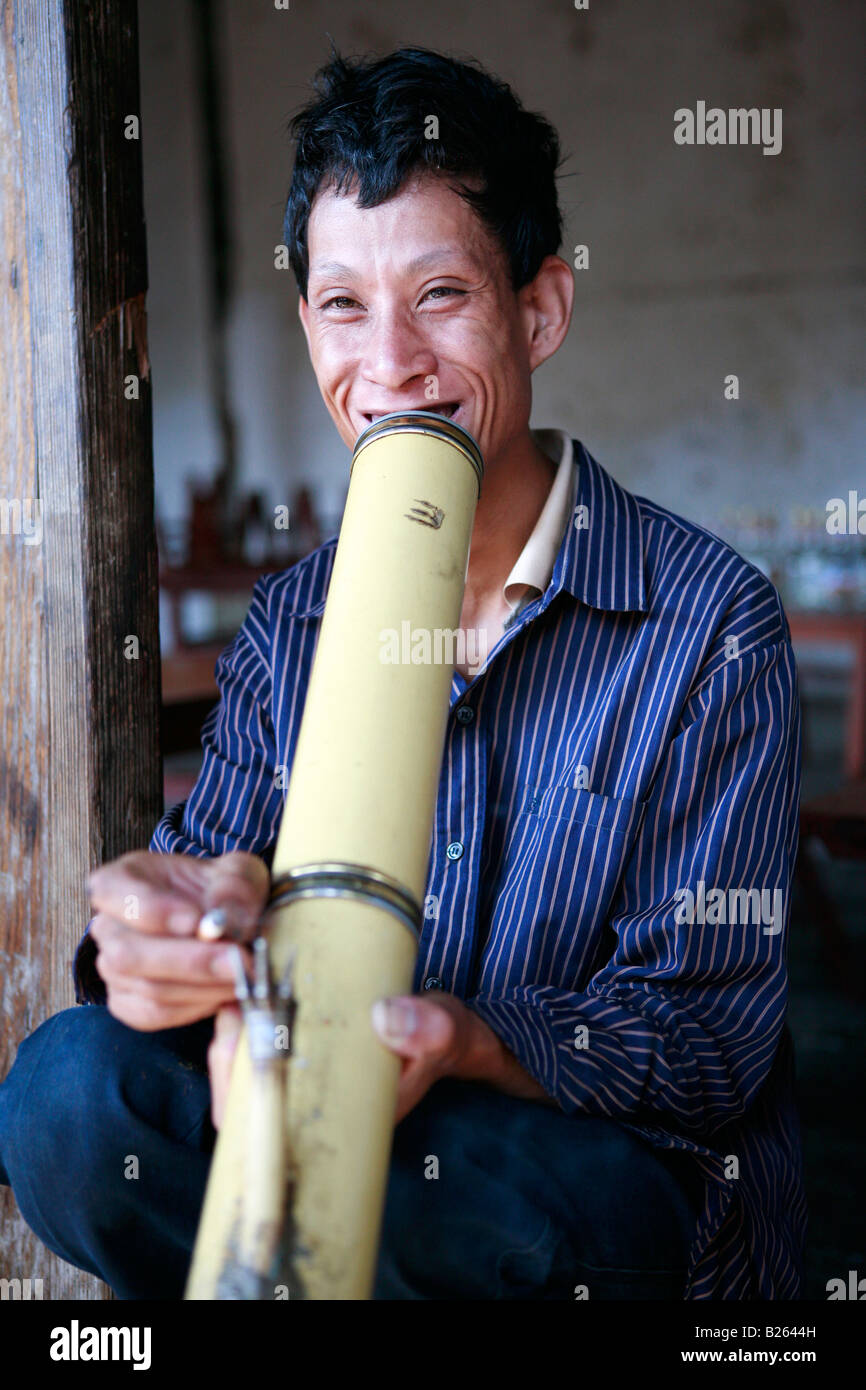 Man smoking a traditional pipe at the village of Tuanshan, near ...