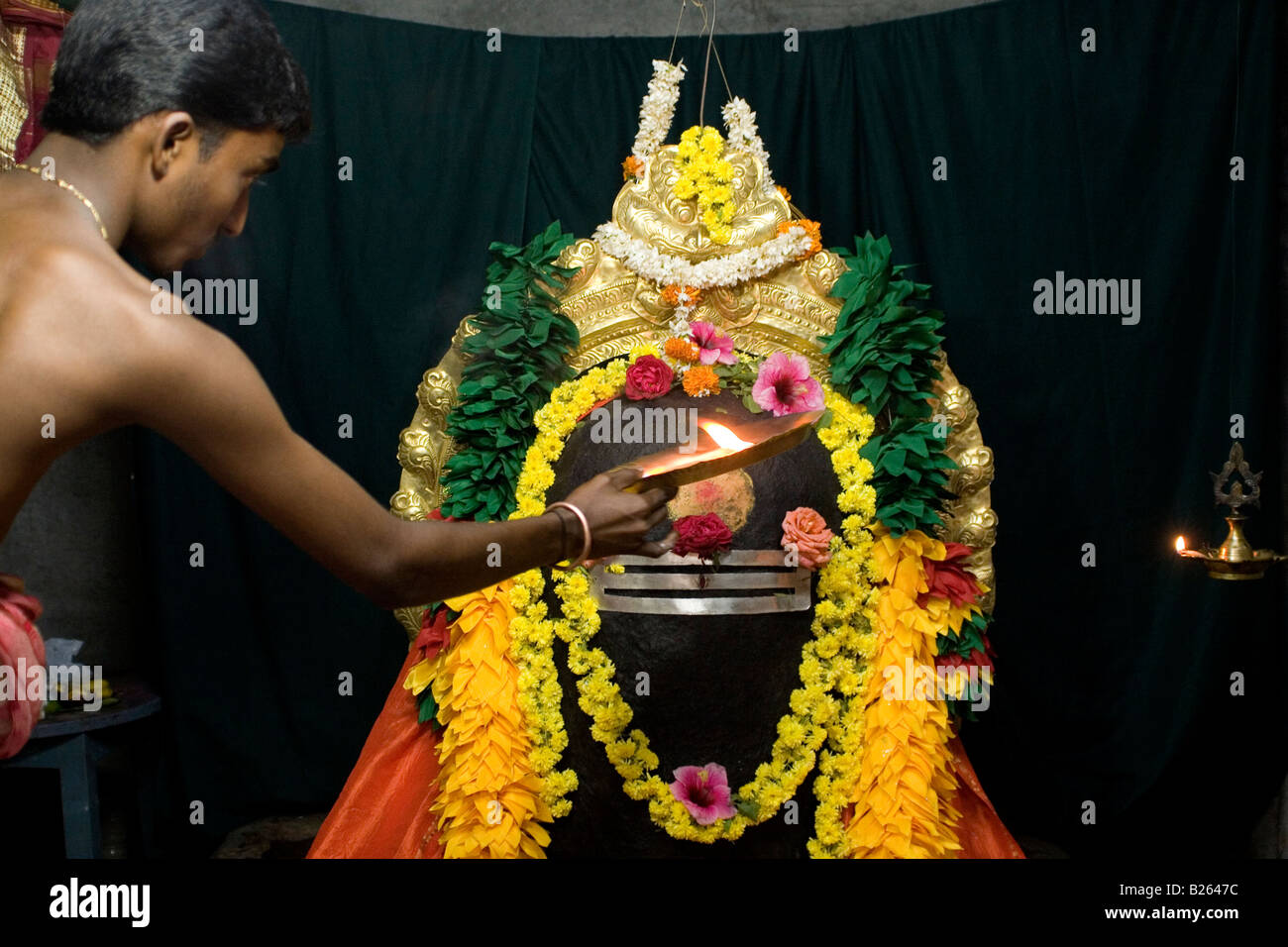 A priest undertakes a puja with one of the sacred Lingam at Talakkad in ...