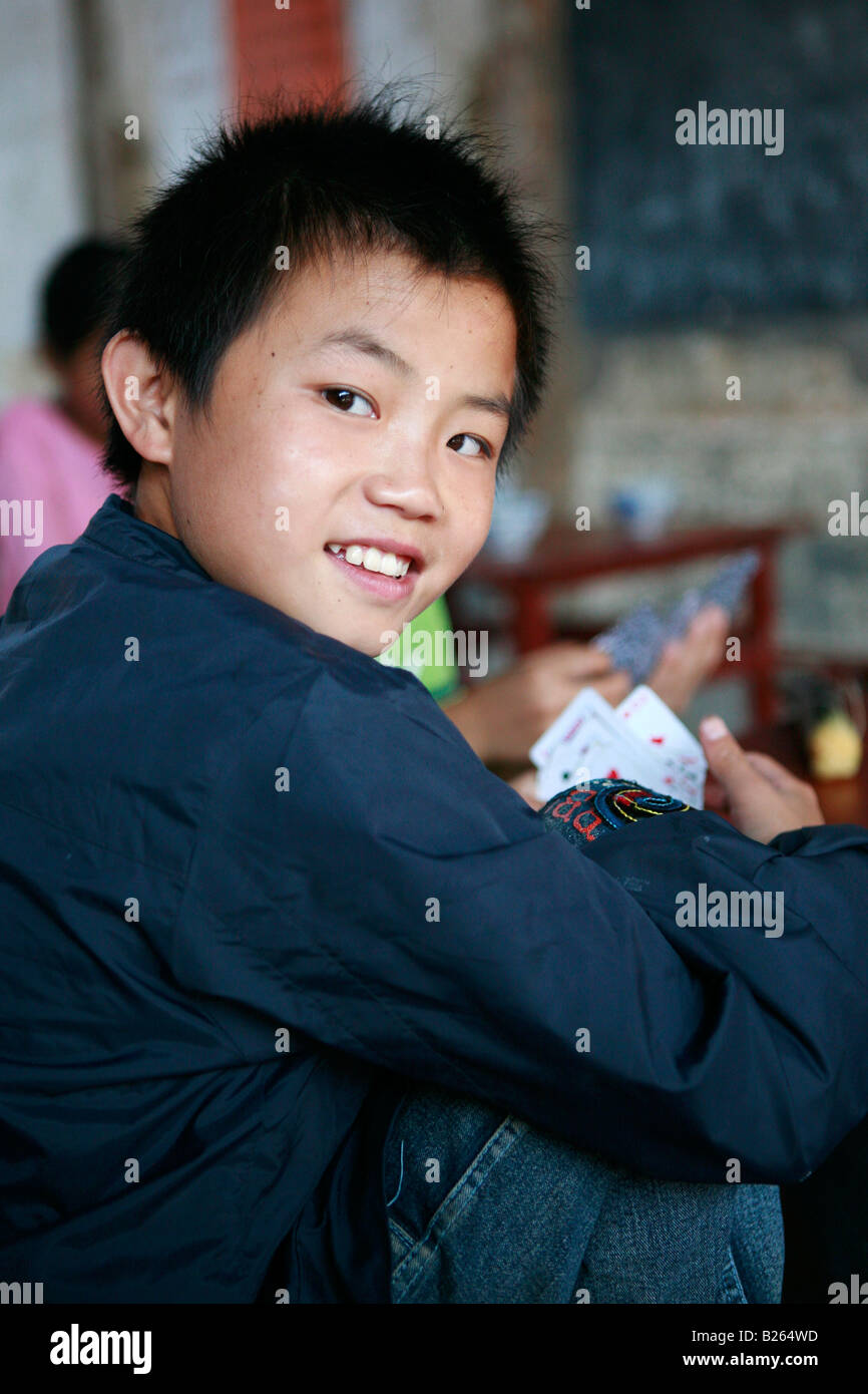 Chinese boy playing cards at the village of Tuanshan, Yunnan, China ...