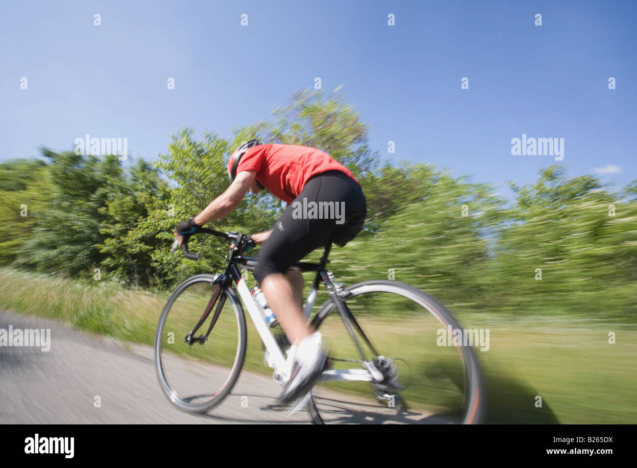 Side view of a cyclist cycling on road, blurred motion Stock Photo - Alamy