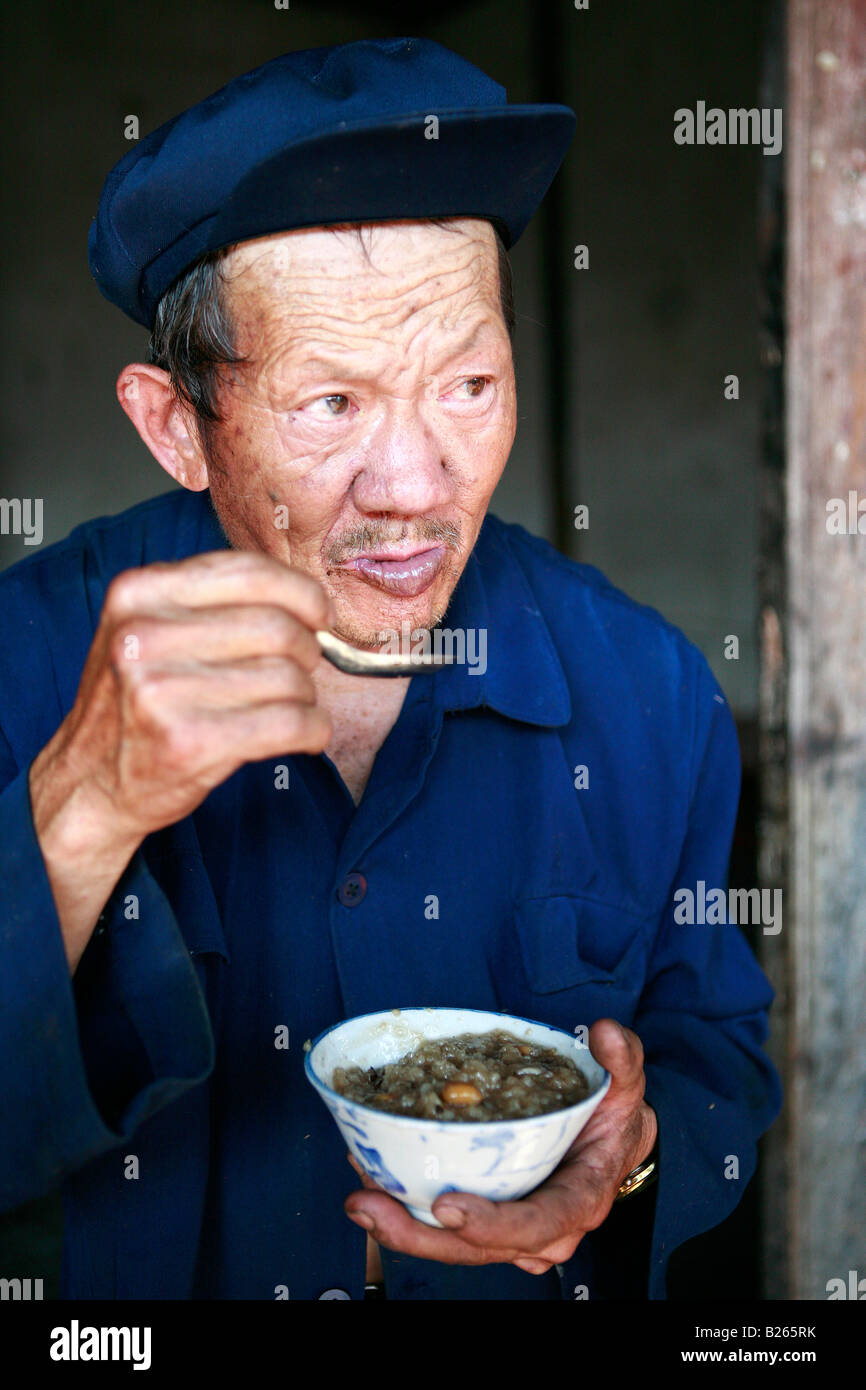 Chinese man eating breakfast at the village of Tuanshan, Yunnan, China ...