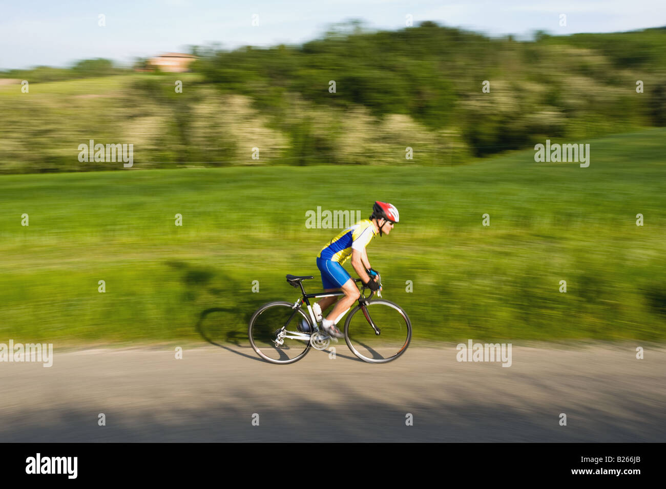 Side view of a man cycling on road Stock Photo - Alamy