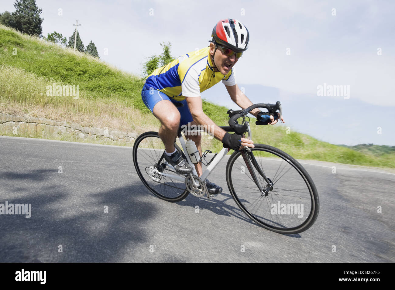 Side view of a man cycling on road Stock Photo - Alamy