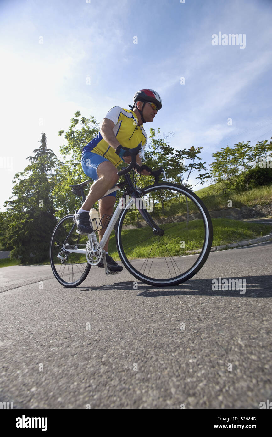 Side view of a man cycling on road Stock Photo - Alamy