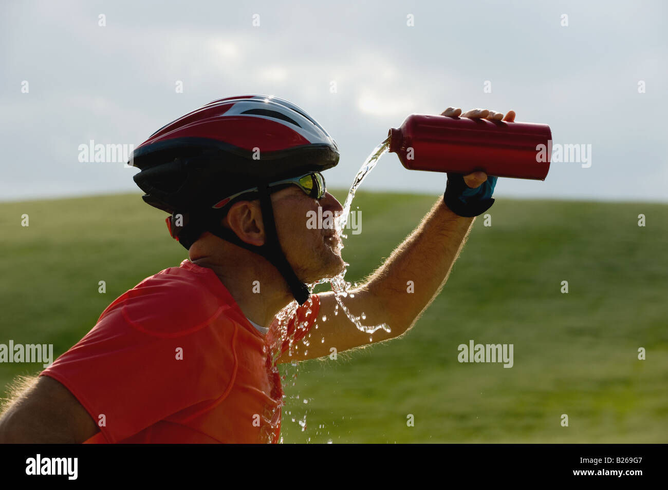 Side view of a cyclist drinking water Stock Photo - Alamy
