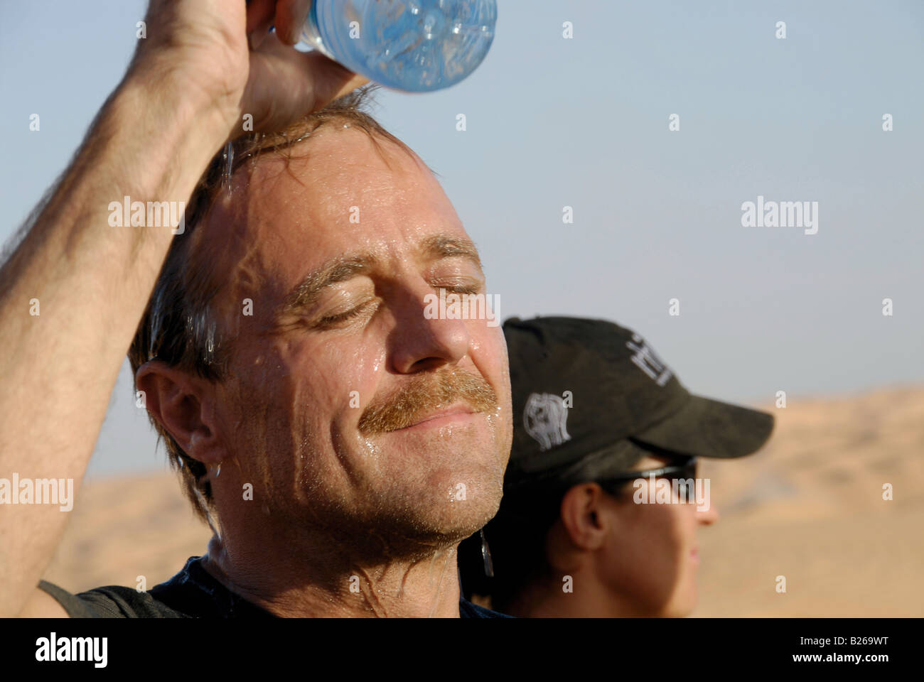 Man pouring water over his head in the hot desert sun, Cool down ...
