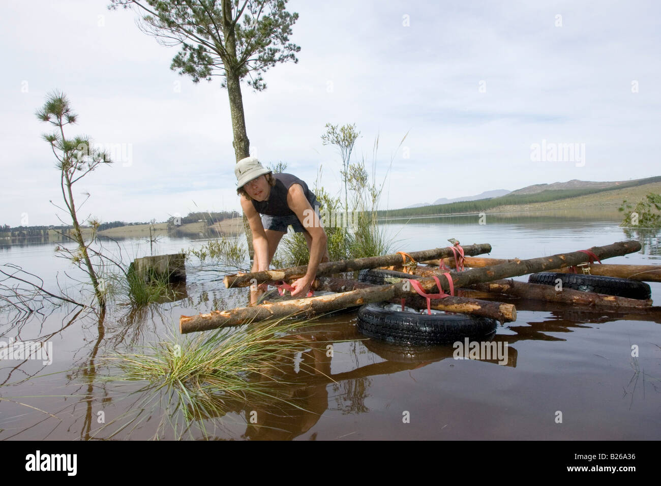 Man building a raft in water, Grabouw Forest Park, near Cape Town ...