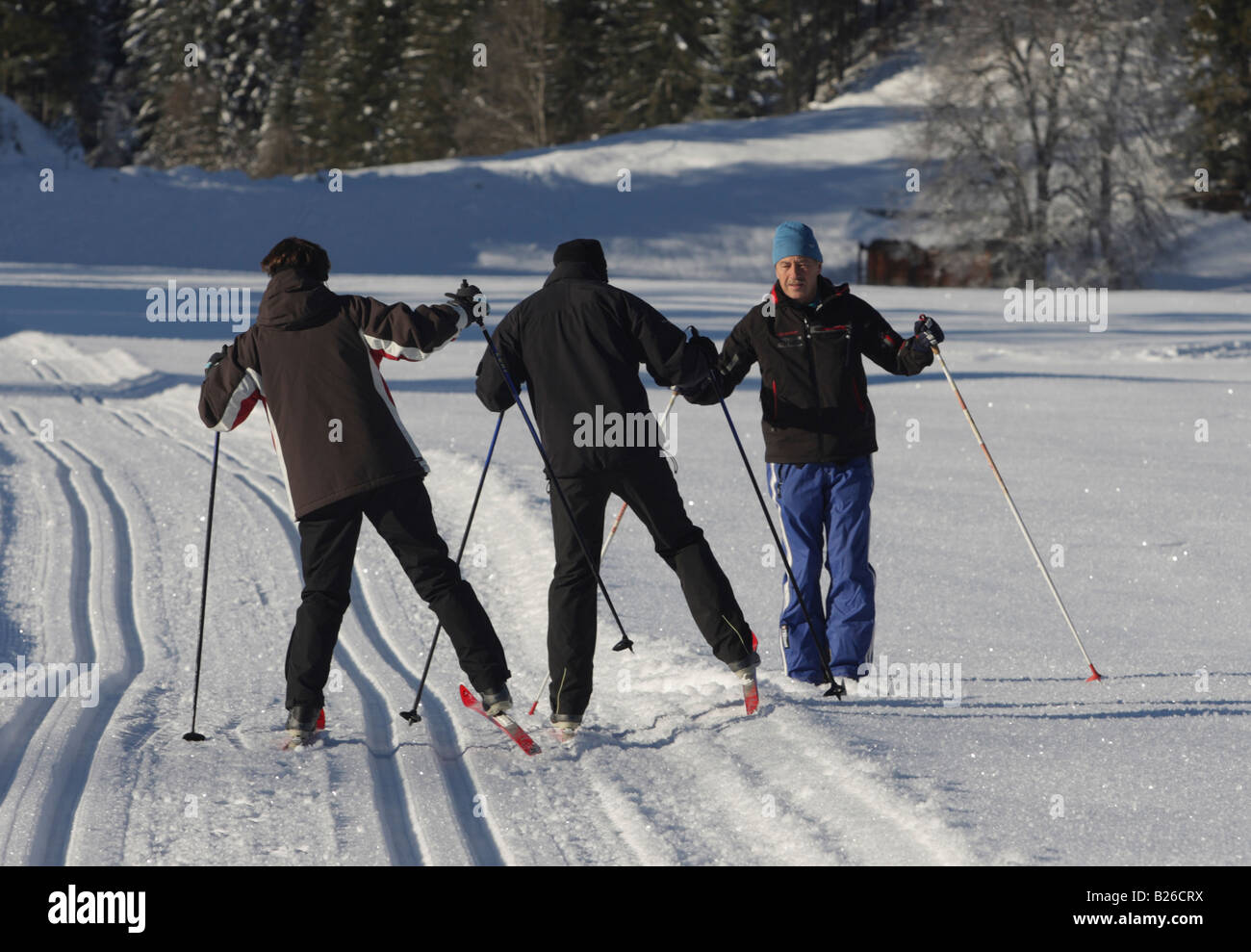 Ski instructor teaching two people nordic skiing Stock Photo - Alamy