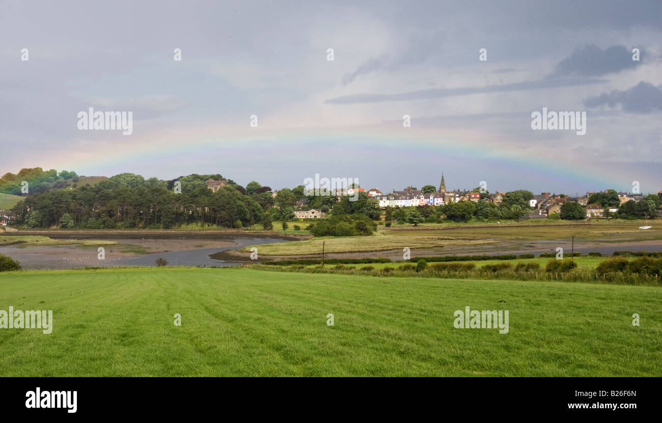 Rainbow over grassland with trees and houses in countryside Stock Photo ...