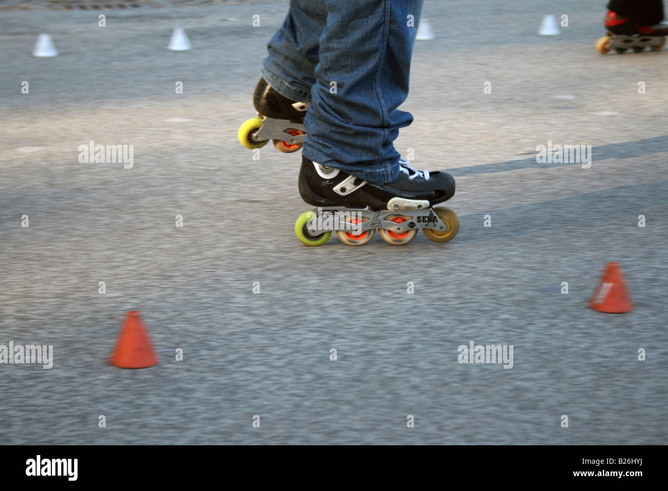 fast rollerskater doing obstacle course cones in street in park Stock ...