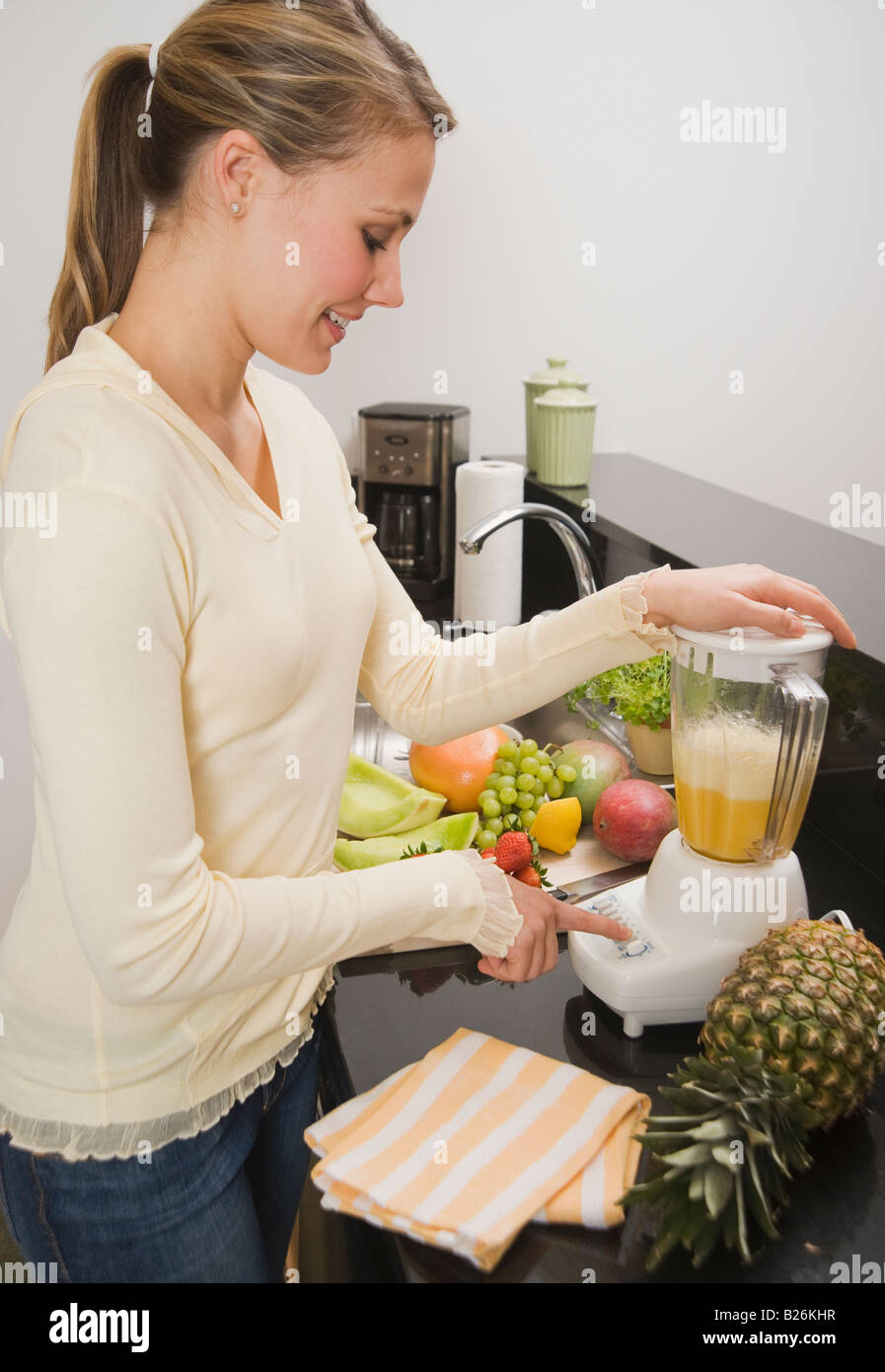 Woman pushing button on blender Stock Photo - Alamy