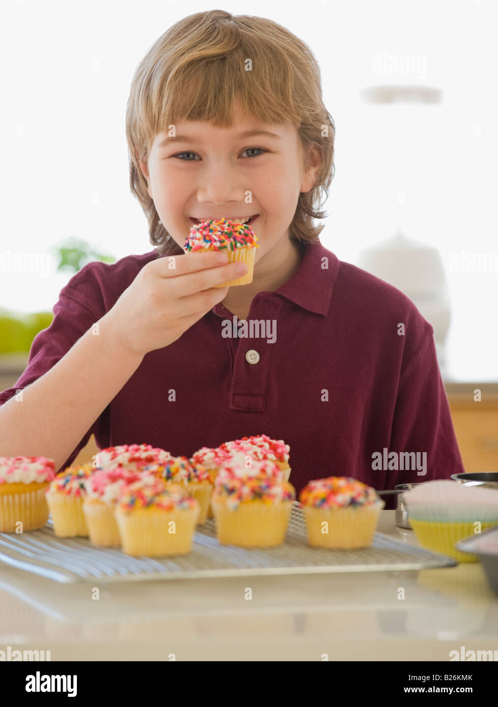 Boy eating home-made cupcake Stock Photo - Alamy