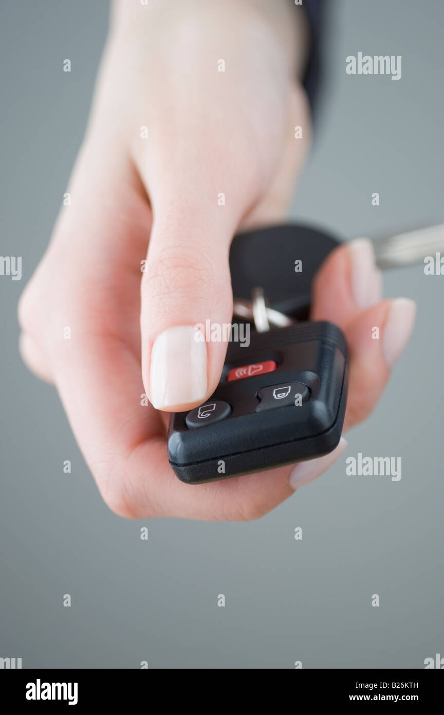 Woman pressing unlock button on keychain Stock Photo - Alamy
