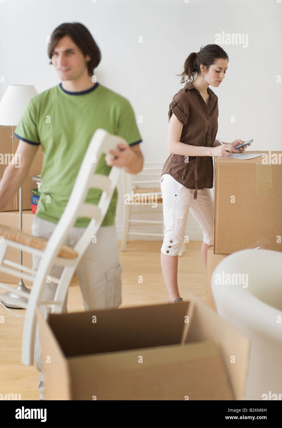 Couple and moving boxes in new home Stock Photo - Alamy