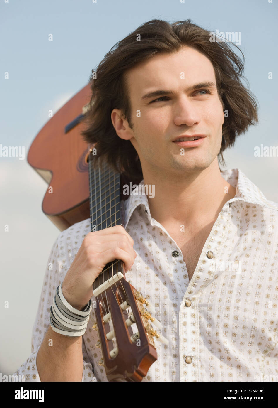 Man holding guitar on shoulder Stock Photo - Alamy