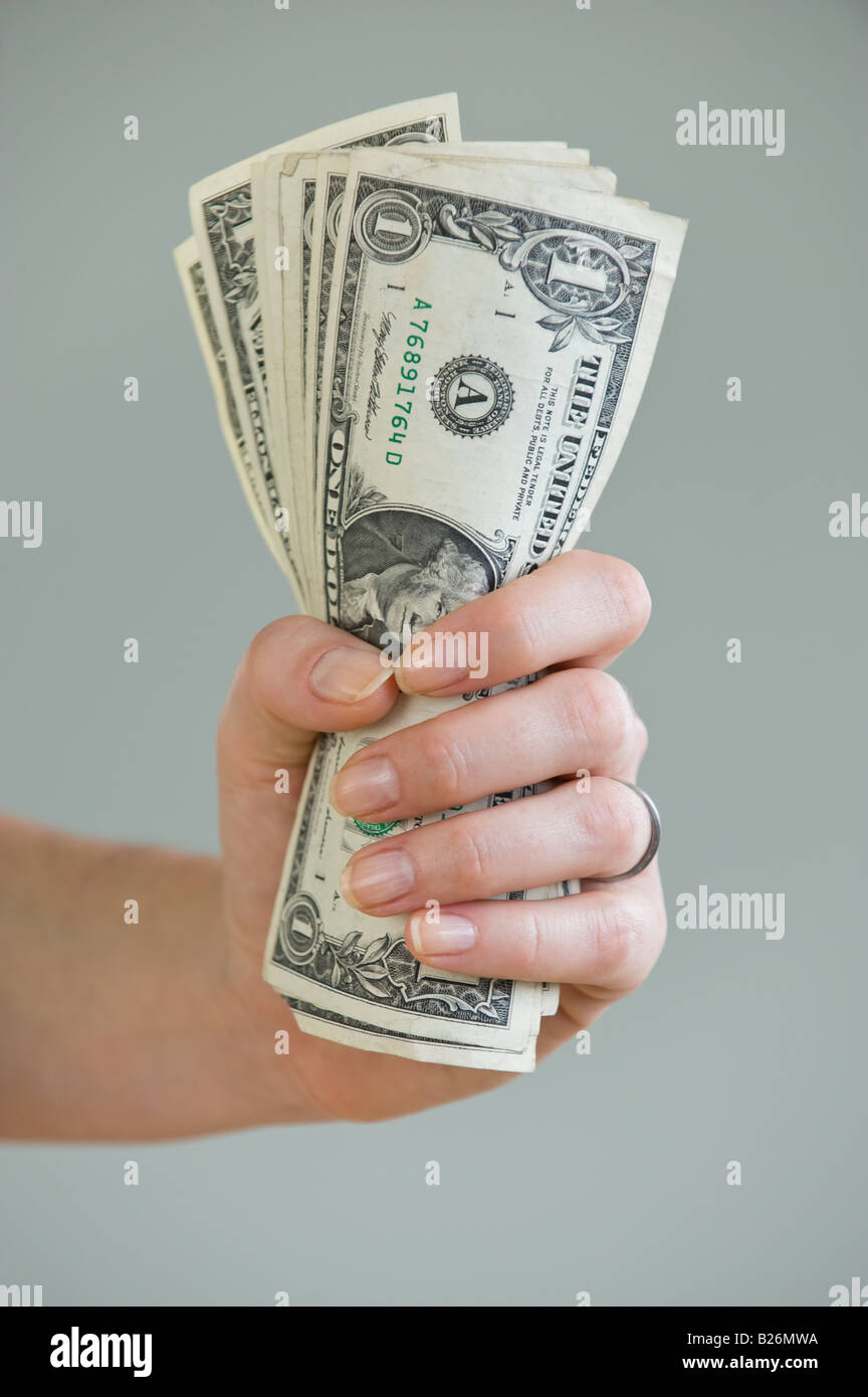 Woman holding handful of money Stock Photo - Alamy