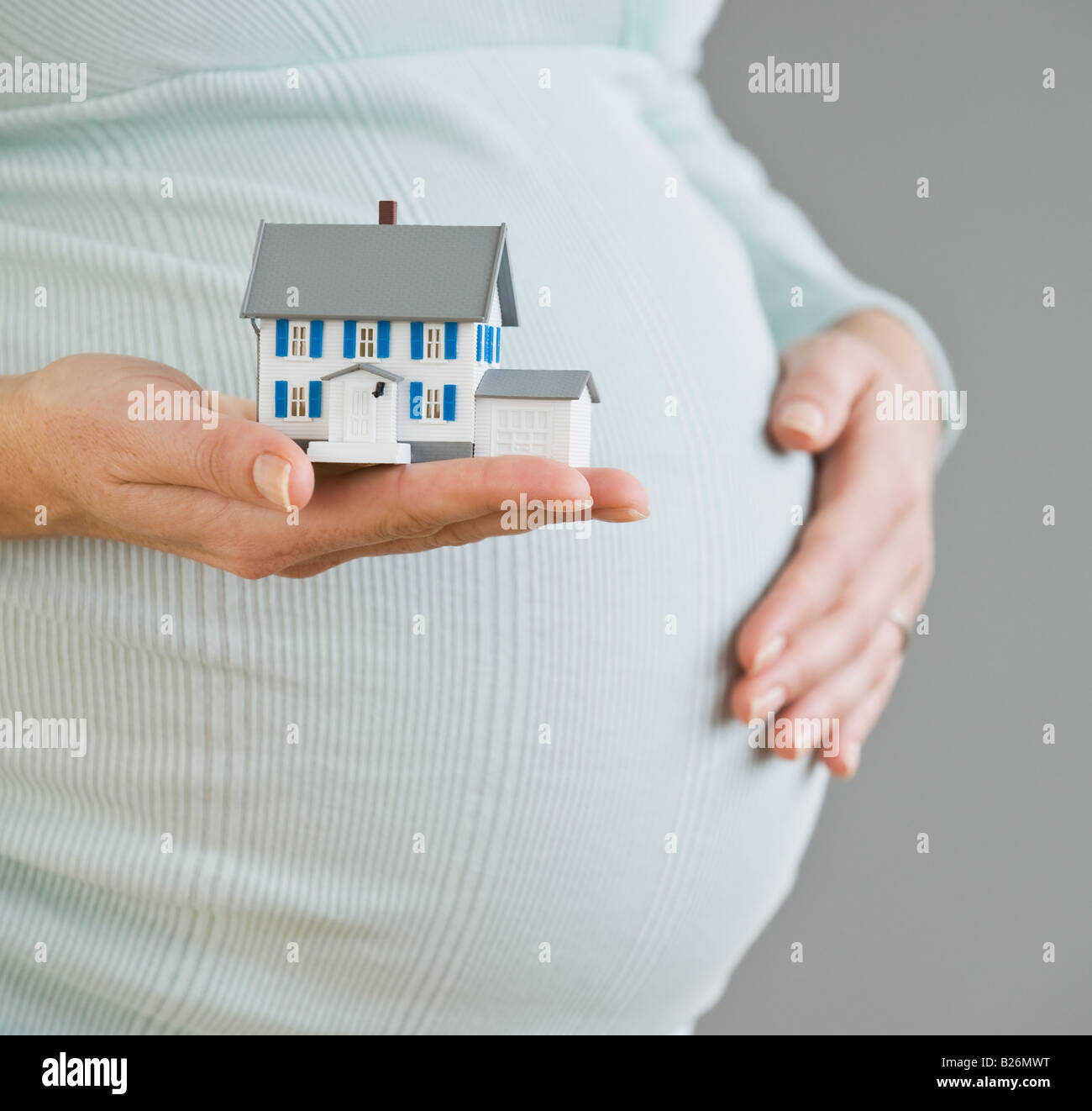 Pregnant woman holding model house hi-res stock photography and images ...