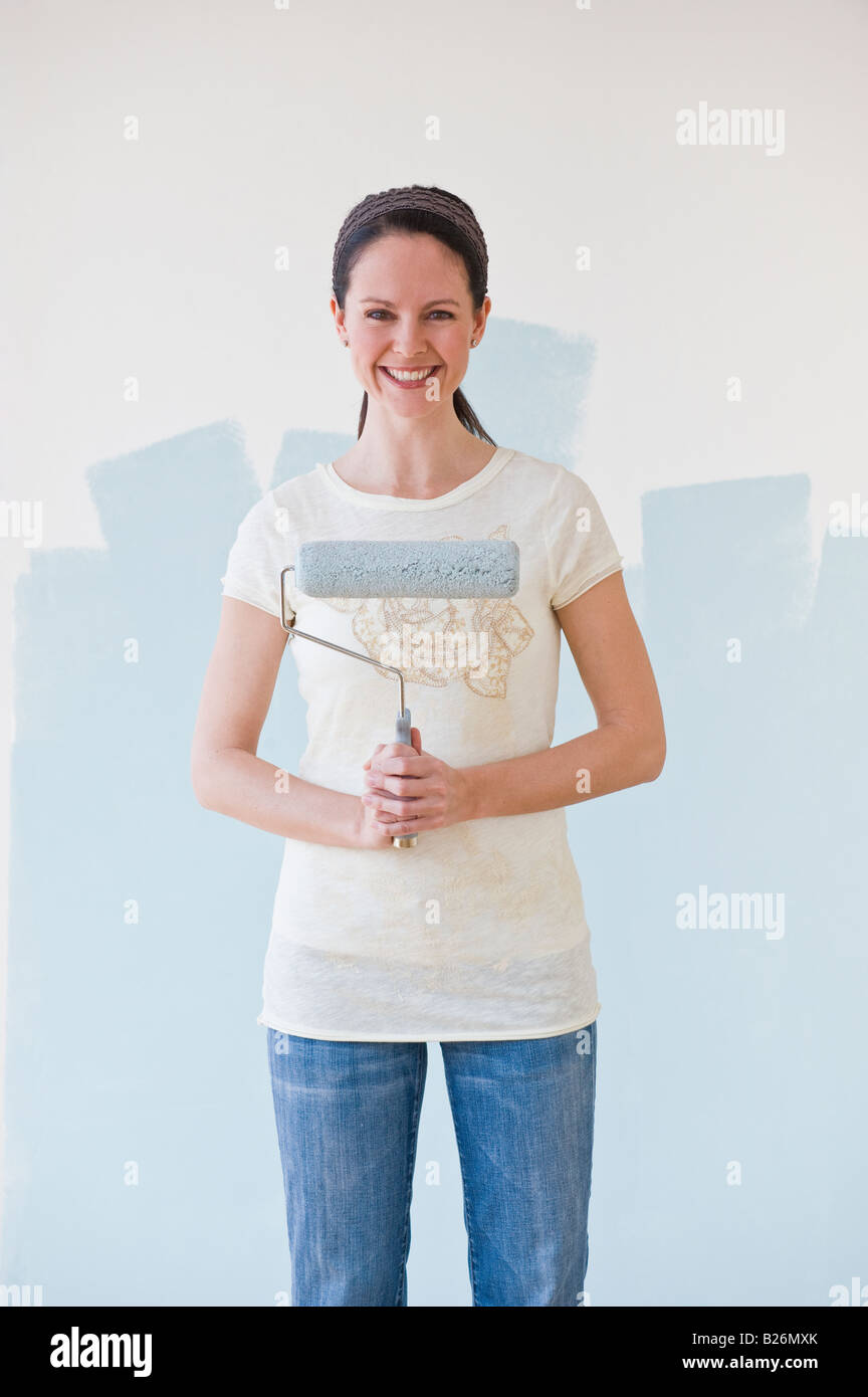 Woman holding paint roller Stock Photo - Alamy