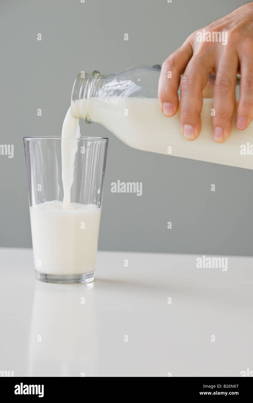 Man pouring milk into glass Stock Photo - Alamy