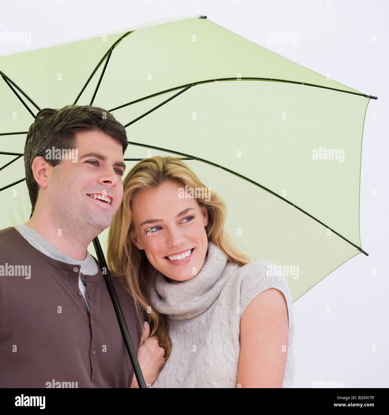 Couple standing under umbrella Stock Photo - Alamy
